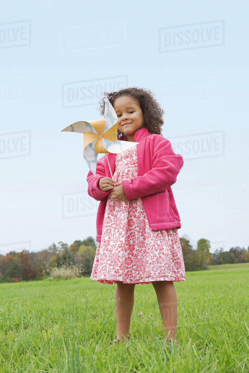 Girl playing with toy windmill - Royalty-free Stock Photo | Dissolve
