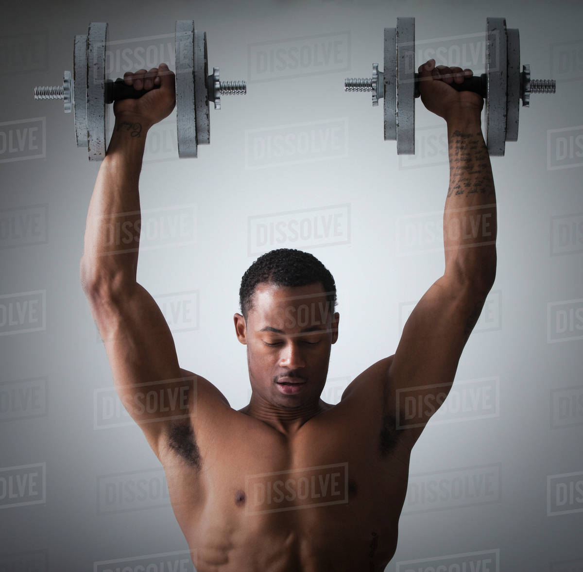 Muscular man lifting dumbbells - Royalty-free Stock Photo | Dissolve