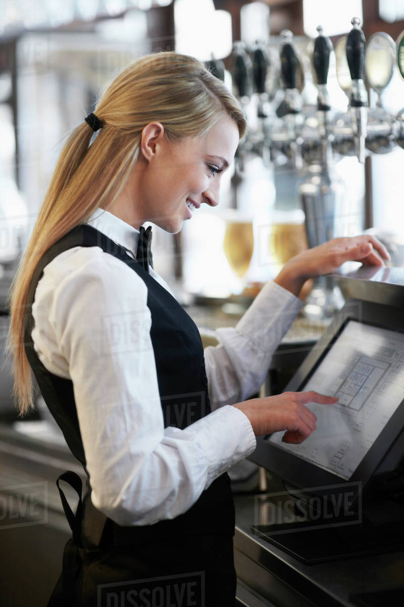 Young waitress using computer at restaurant counter - Royalty-free ...