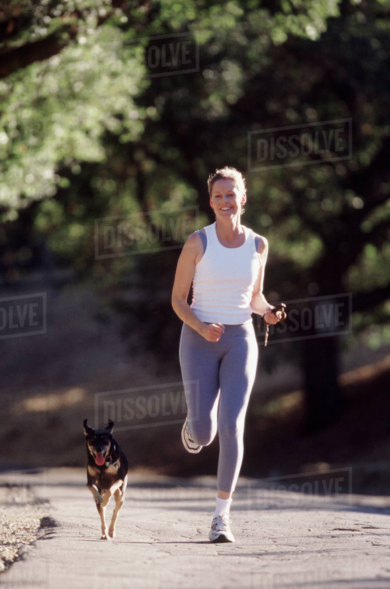 Woman running with her dog - Royalty-free Stock Photo | Dissolve