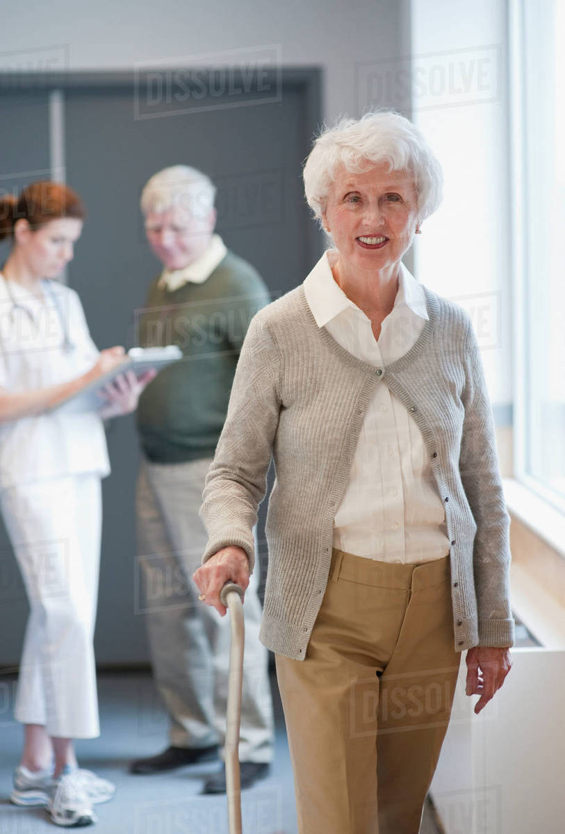 Senior woman walking with cane - Stock Photo - Dissolve
