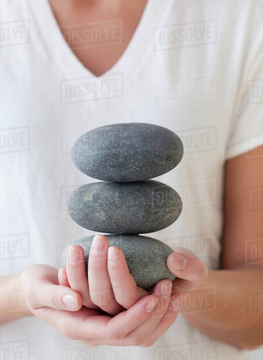 Woman holding stack of spa stones - Royalty-free Stock Photo | Dissolve