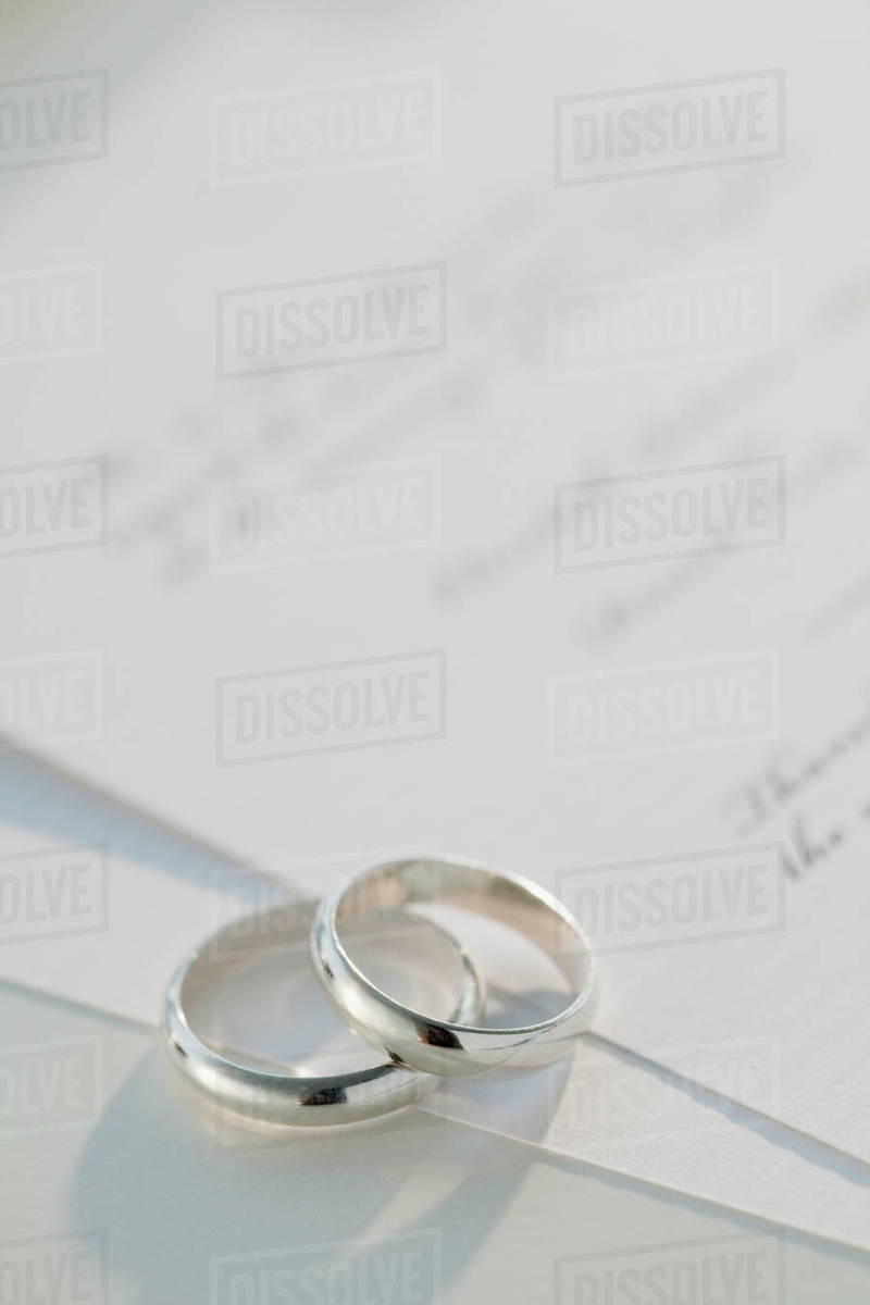 Two wedding rings on marriage certificate, studio shot - Royalty-free ...