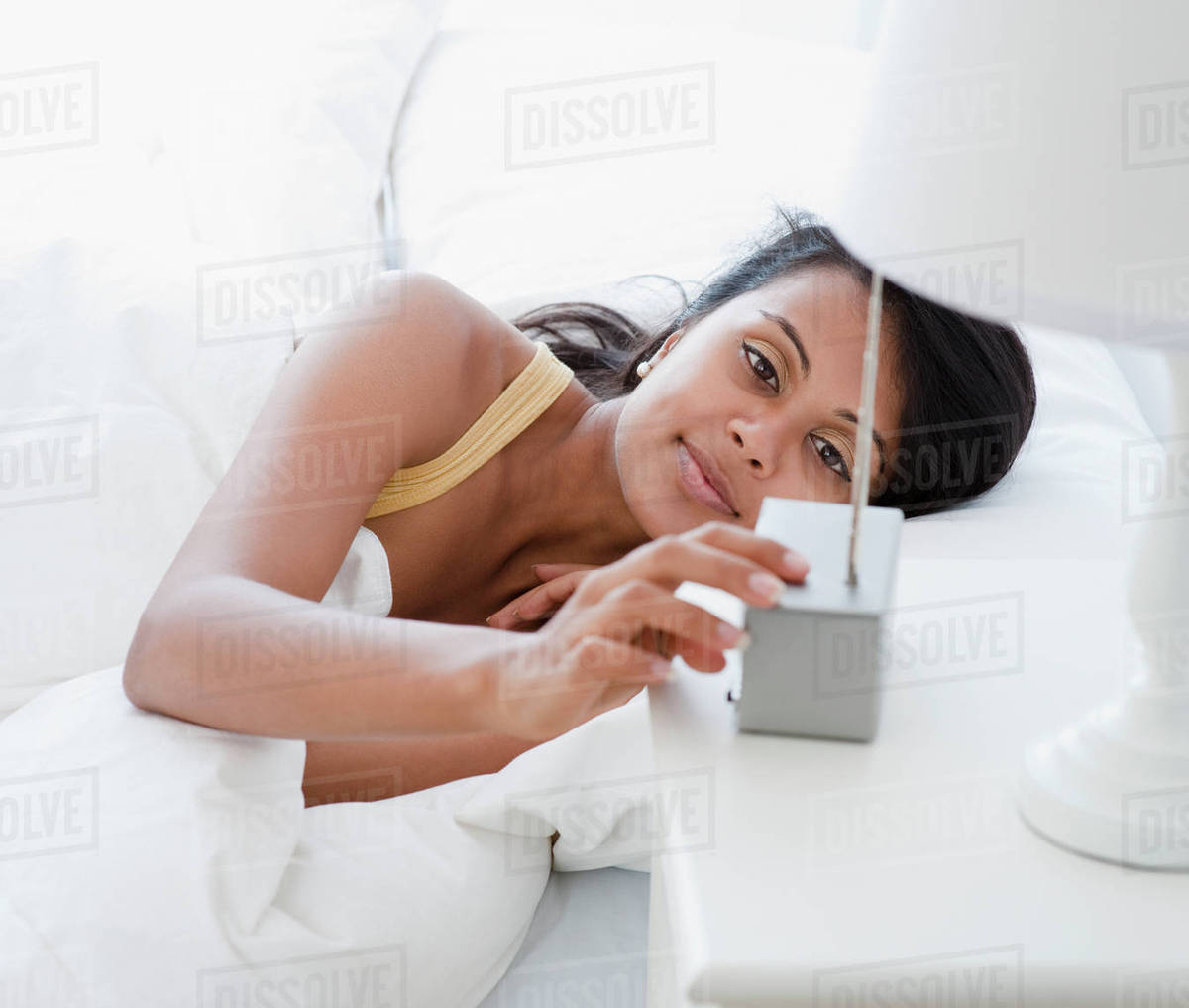 Woman setting alarm clock - Royalty-free Stock Photo | Dissolve