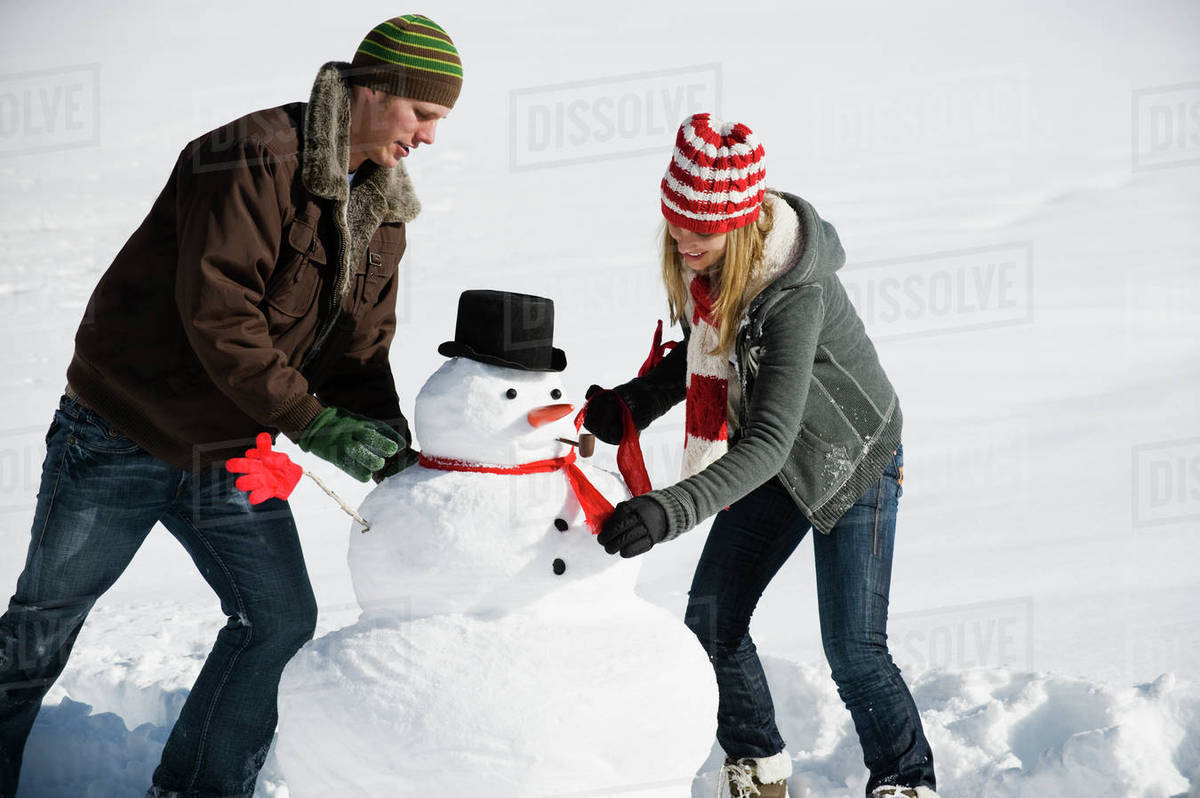 A couple making a snowman - Stock Photo - Dissolve