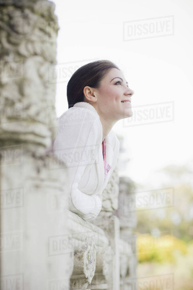 A woman leaning on a railing outdoors - Royalty-free Stock Photo | Dissolve