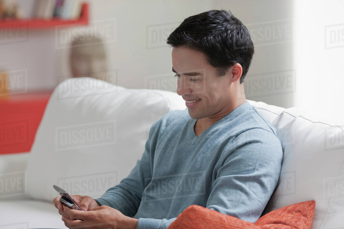 Man texting in living room - Royalty-free Stock Photo | Dissolve