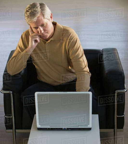 Man looking at laptop - Royalty-free Stock Photo | Dissolve