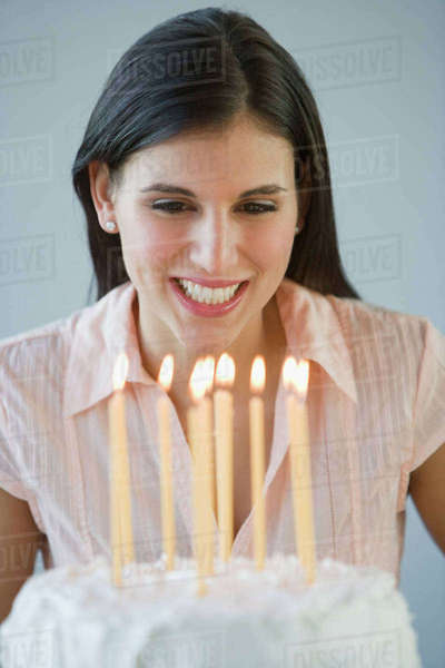 Woman looking at birthday cake - Royalty-free Stock Photo | Dissolve