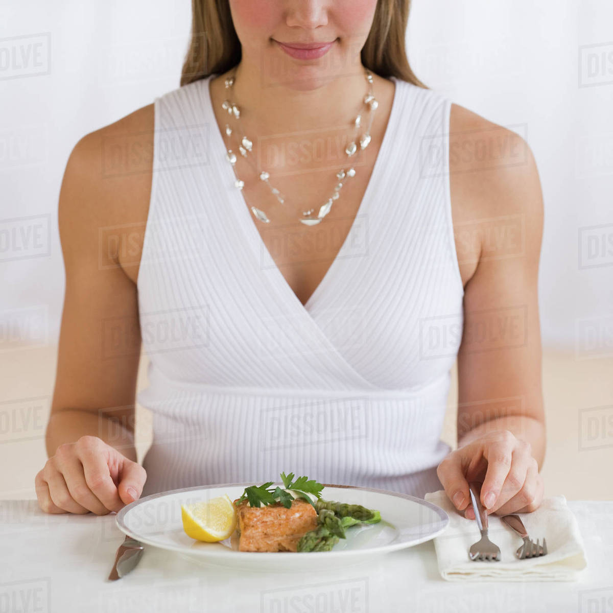 Woman sitting at dinner table - Stock Photo - Dissolve