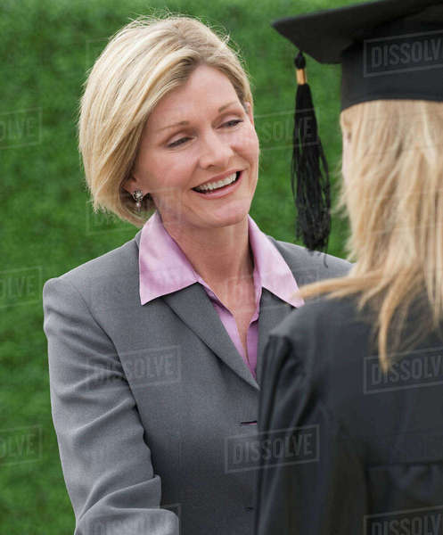Woman talking to graduate - Stock Photo - Dissolve