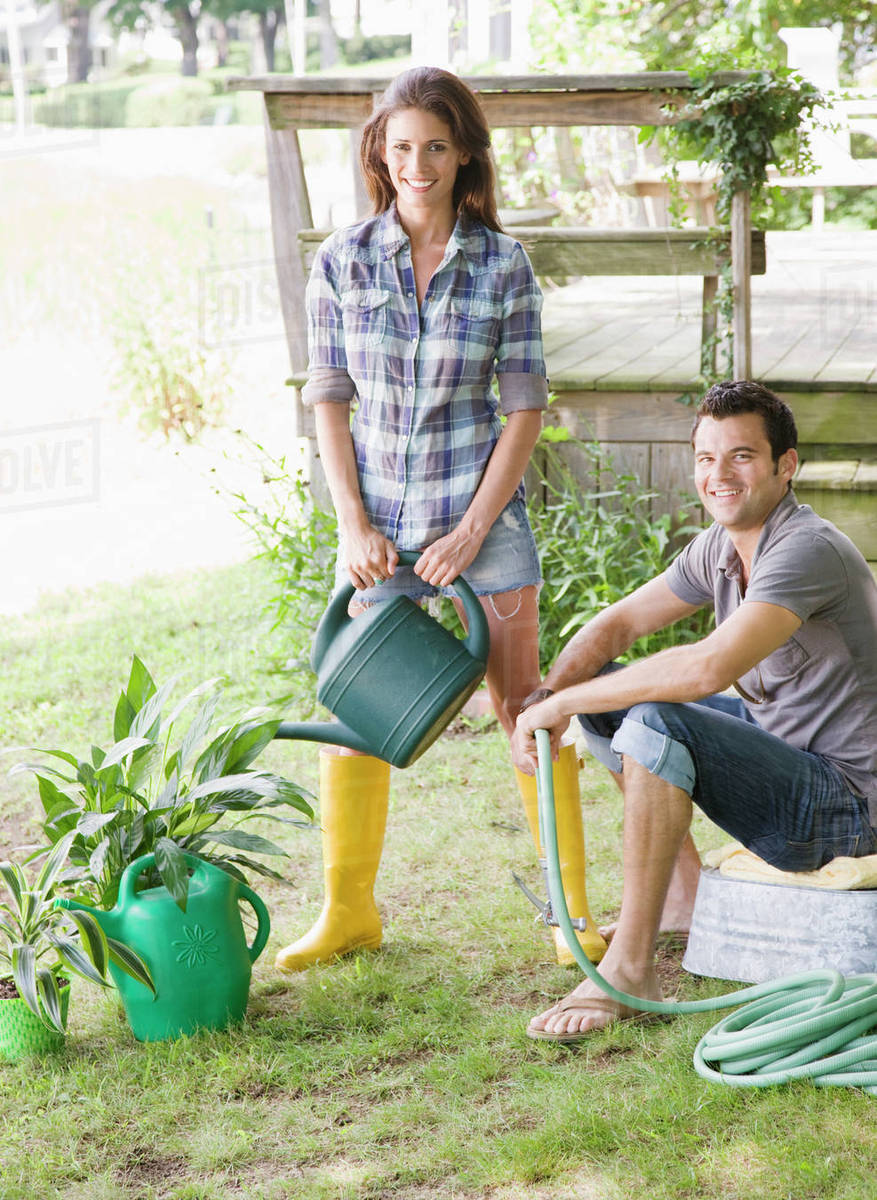 Couple watering plants in backyard - Royalty-free Stock Photo | Dissolve