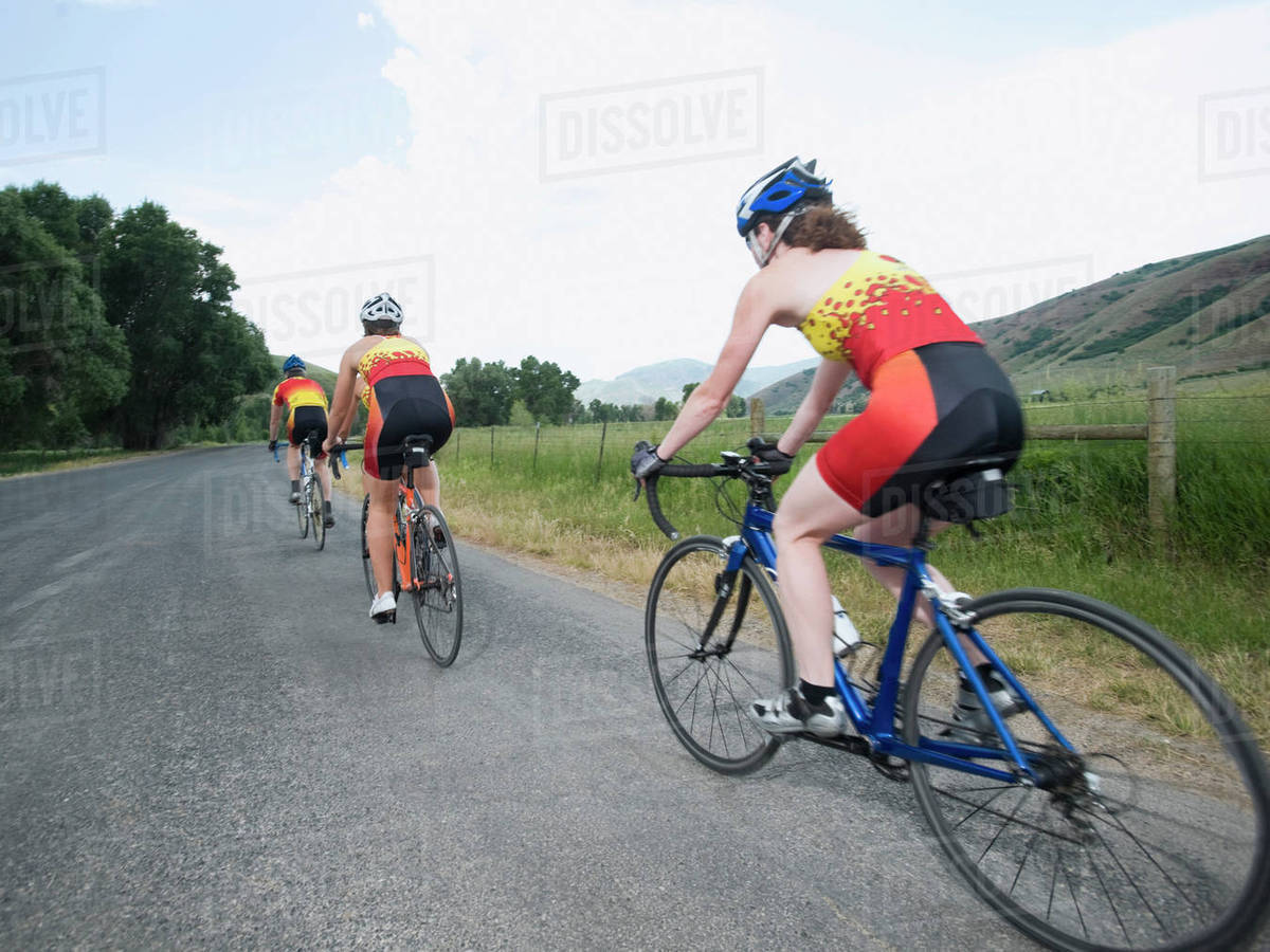 Cyclists in a row on country road - Royalty-free Stock Photo | Dissolve