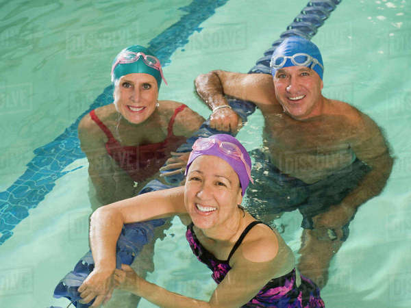 Man and women posing in swimming pool - Stock Photo - Dissolve