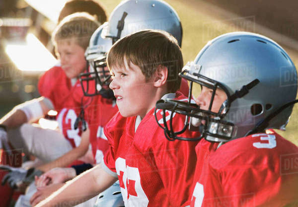 Football players sitting on bench - Royalty-free Stock Photo | Dissolve