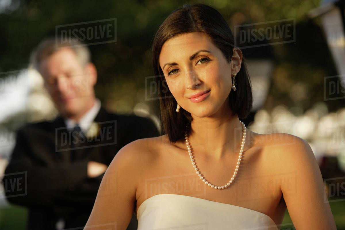 Bride with father in background - Royalty-free Stock Photo | Dissolve
