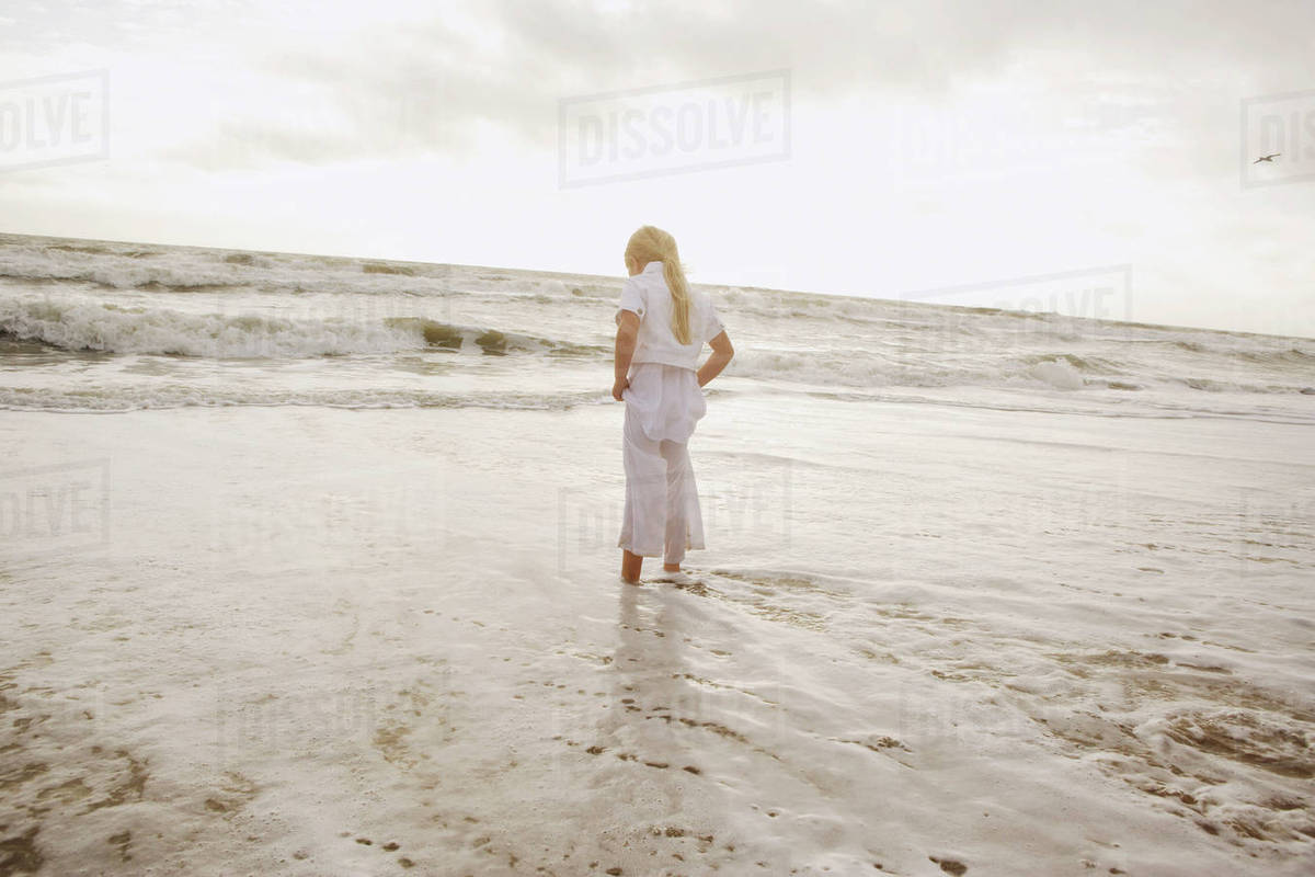 Girl standing in ocean surf - Royalty-free Stock Photo | Dissolve