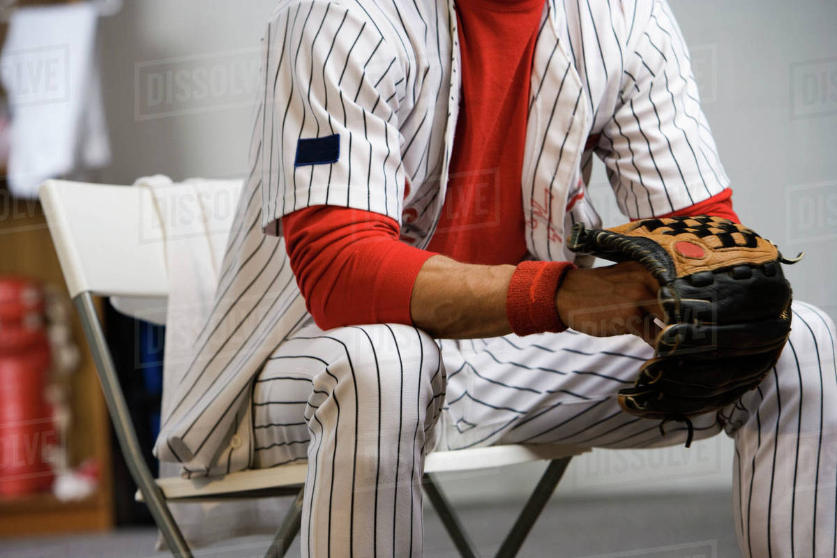 Baseball player holding glove in locker room - Royalty-free Stock Photo ...
