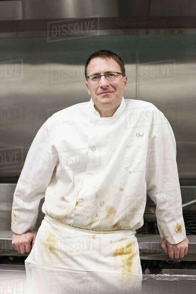 Dirty chef leaning against stove - Royalty-free Stock Photo | Dissolve