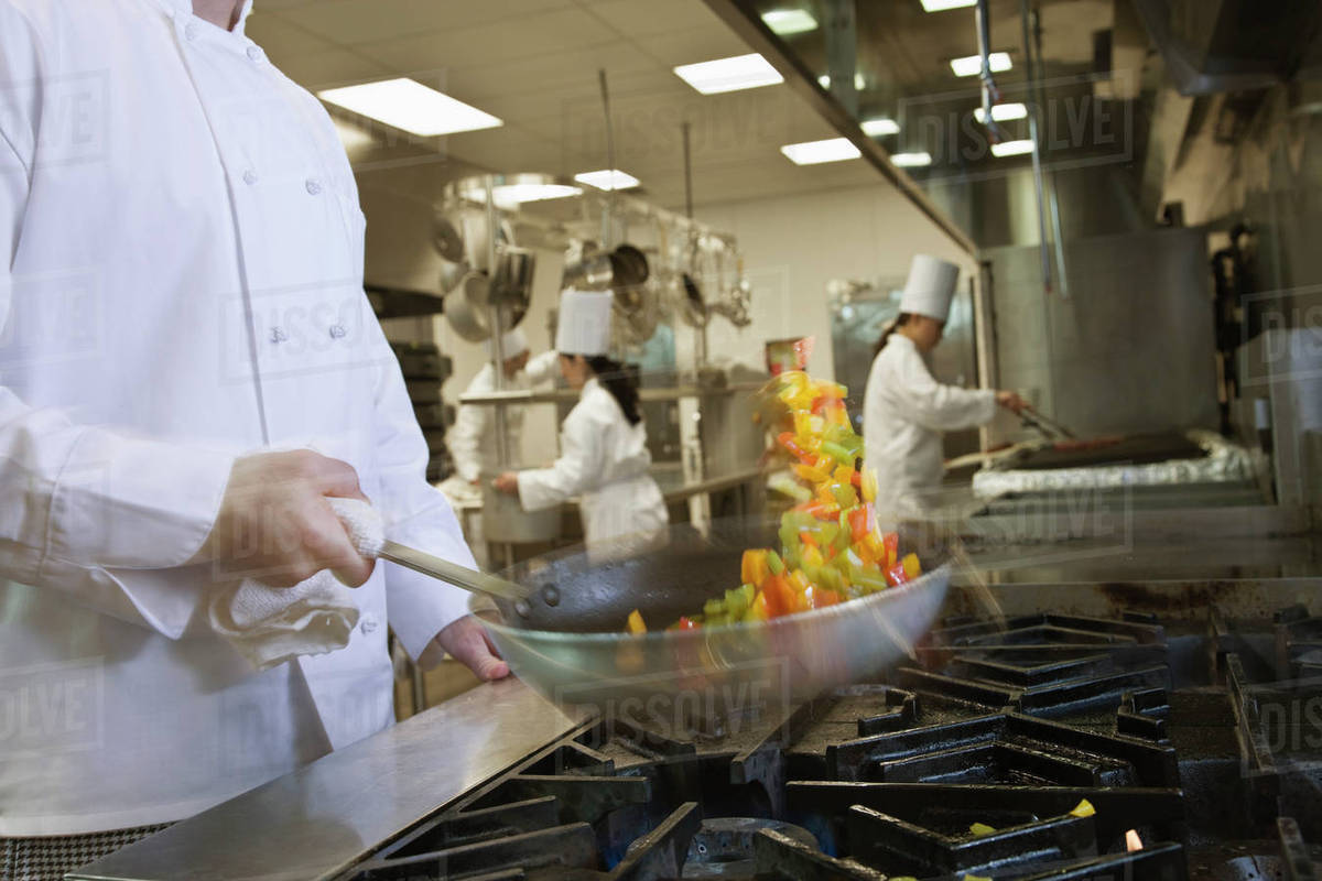 Chef tossing food in skillet - Royalty-free Stock Photo | Dissolve