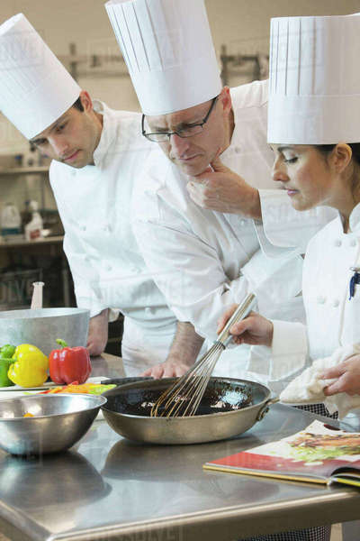 Dirty chefs posing in kitchen - Stock Photo - Dissolve
