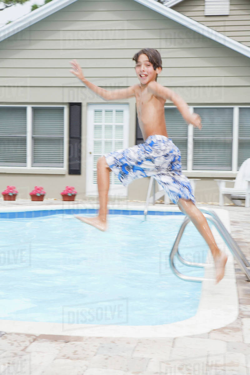 Boy jumping into swimming pool - Royalty-free Stock Photo | Dissolve