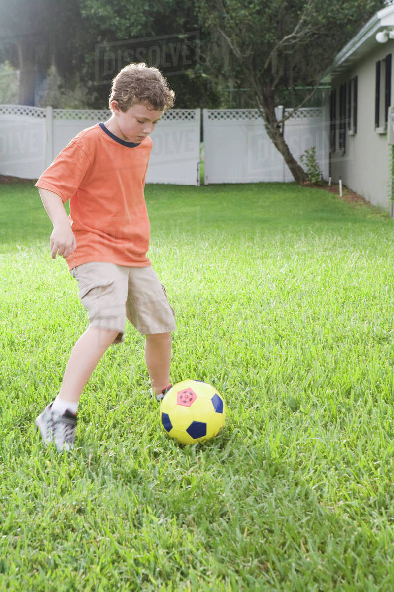 Boy playing in soccer in backyard - Royalty-free Stock Photo | Dissolve