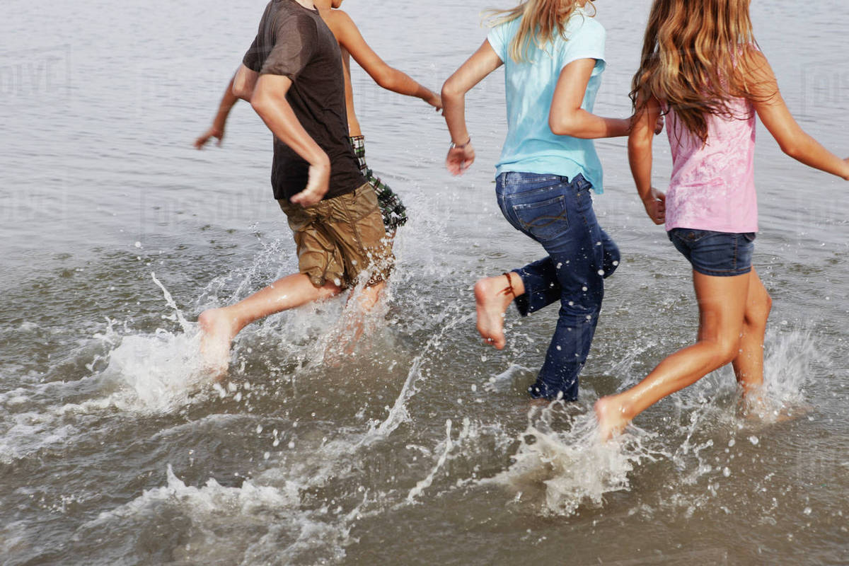 Children running in ocean - Stock Photo - Dissolve