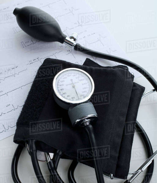 Blood pressure cuff on heart rate printout - Stock Photo - Dissolve