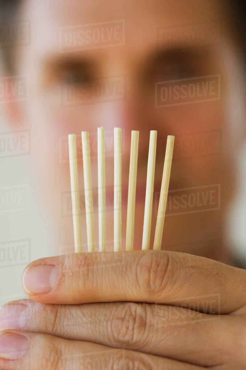 Man holding toothpicks - Royalty-free Stock Photo | Dissolve