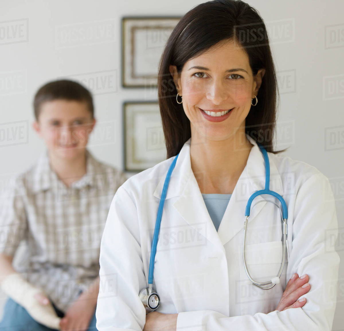Female doctor with boy in background - Royalty-free Stock Photo | Dissolve
