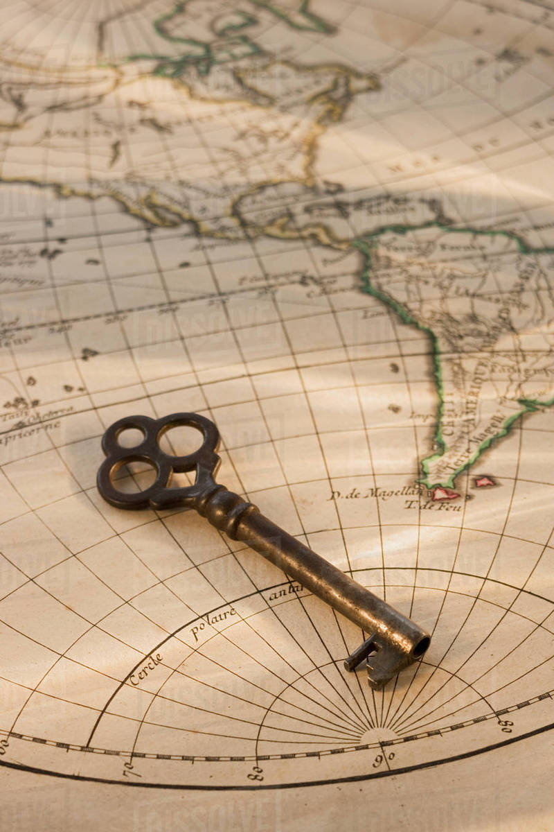 Old fashioned key on globe map - Stock Photo - Dissolve