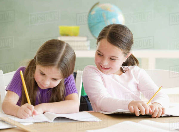 Two girls studying in classroom - Royalty-free Stock Photo | Dissolve