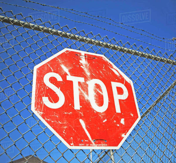 Stop sign on fence - Royalty-free Stock Photo | Dissolve