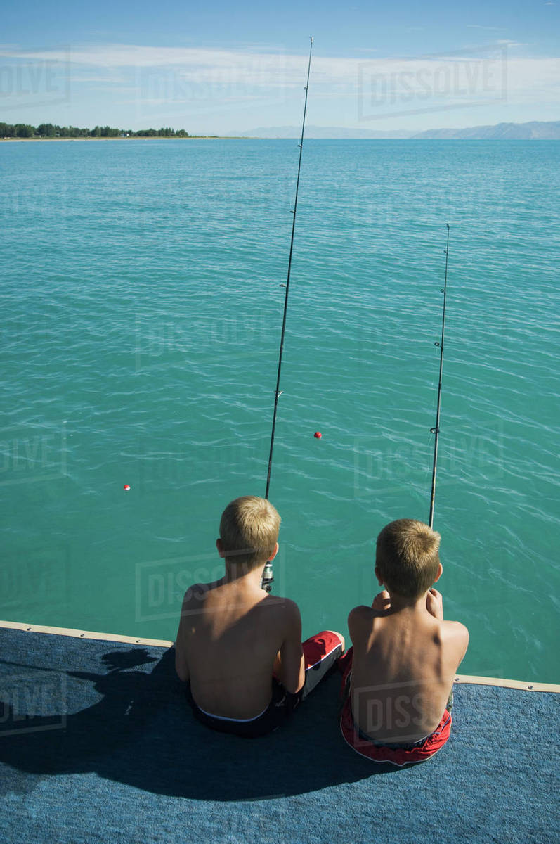 Brothers fishing off dock in lake, Utah, United States - Royalty-free ...