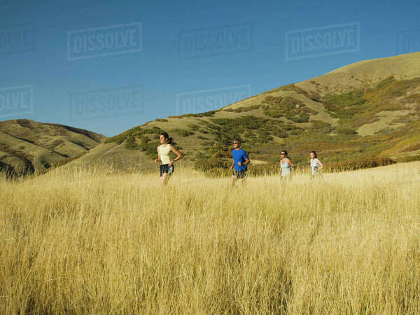 Group of people running in field, Utah, United States - Royalty-free ...