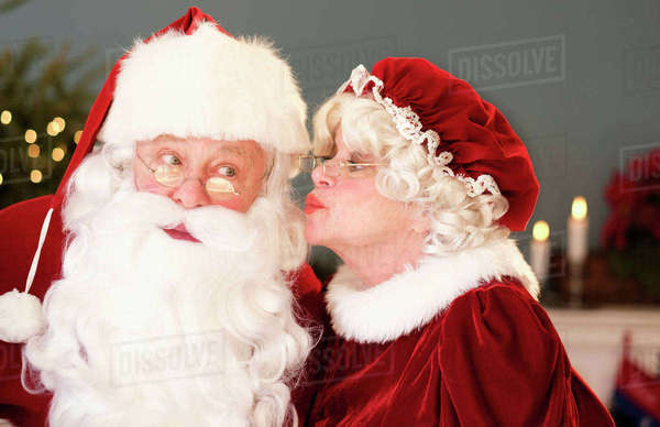 Mrs. Claus kissing Santa on cheek - Royalty-free Stock Photo | Dissolve