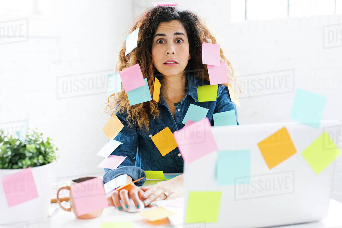 Woman covered with sticky notes using laptop at table - Royalty-free ...