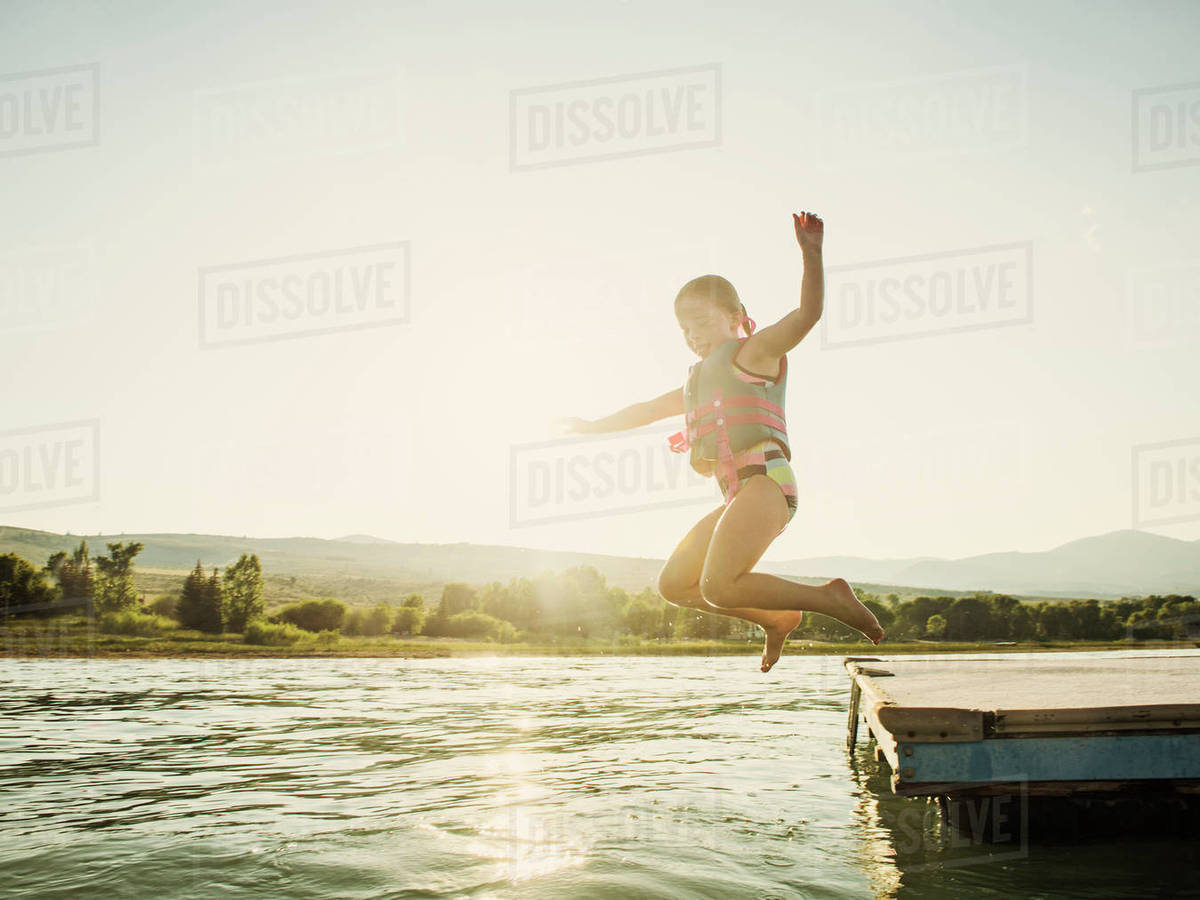 Girl (4-5) jumping into lake from pier - Royalty-free Stock Photo ...