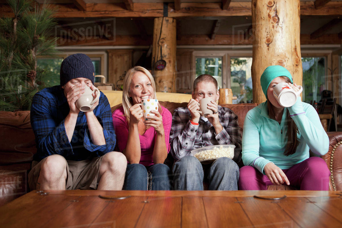 Friends drinking tea in log cabin - Royalty-free Stock Photo | Dissolve