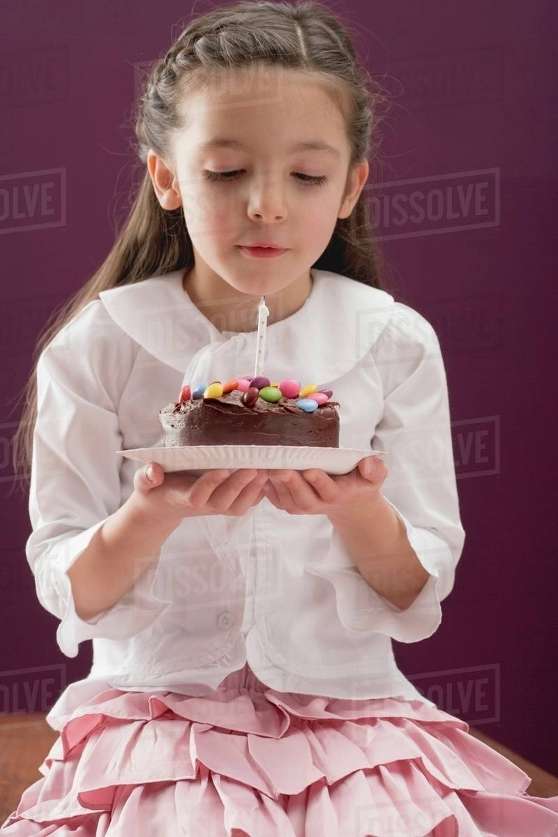 Little girl holding birthday cake - Royalty-free Stock Photo | Dissolve