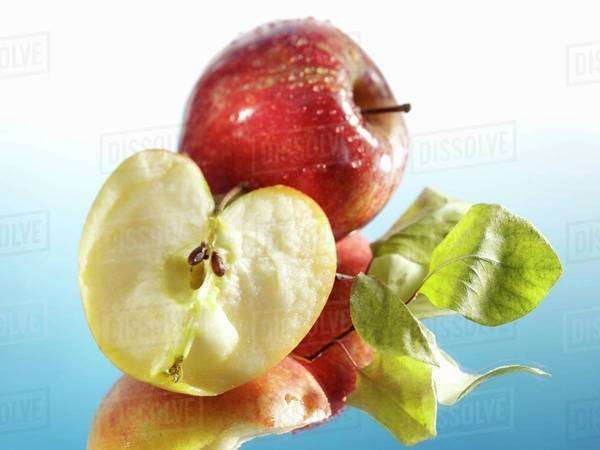Whole apple and half an apple with leaves - Stock Photo - Dissolve