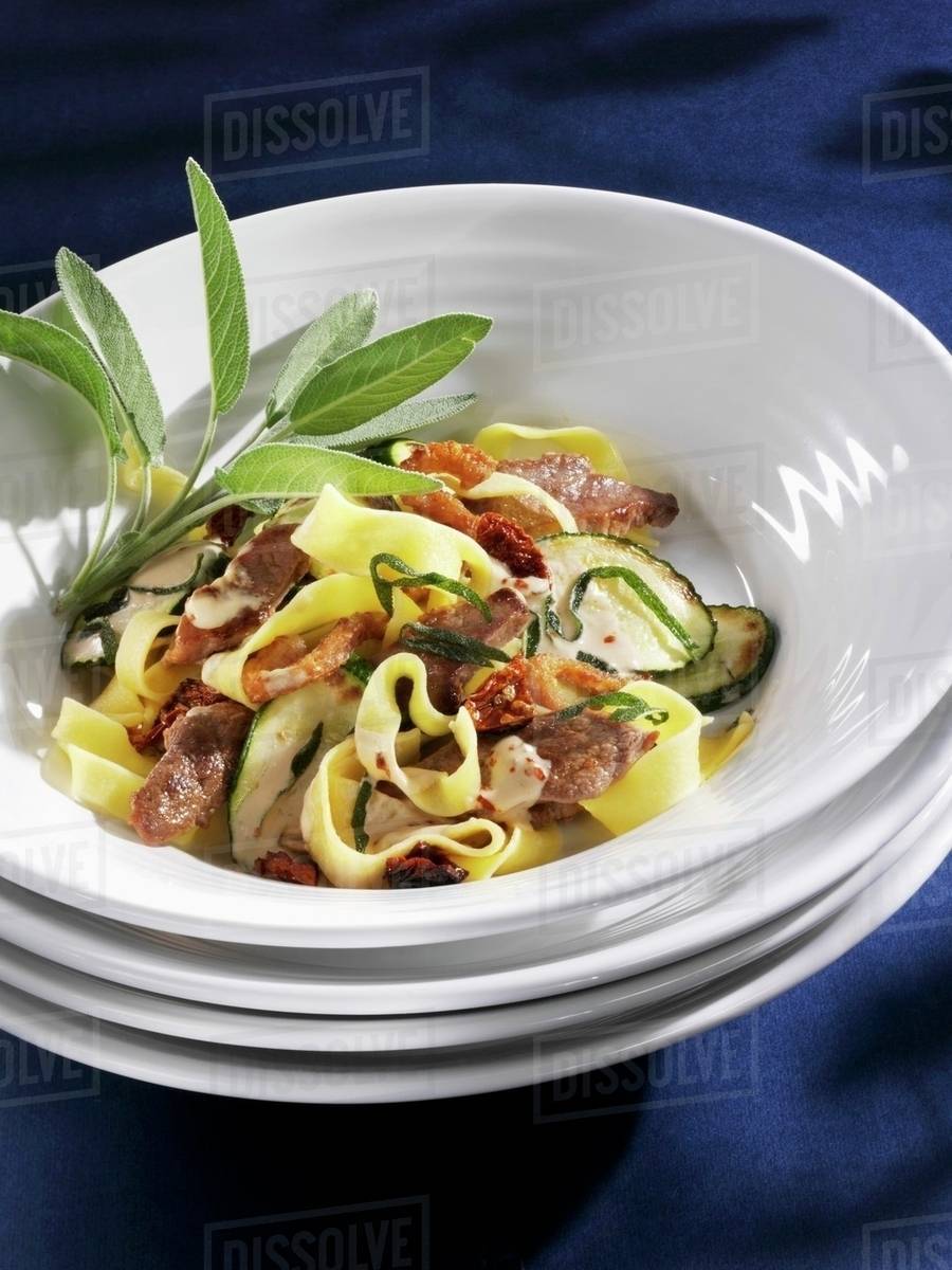 Tagliatelle with fried duck breast, courgettes and sage - Royalty-free ...