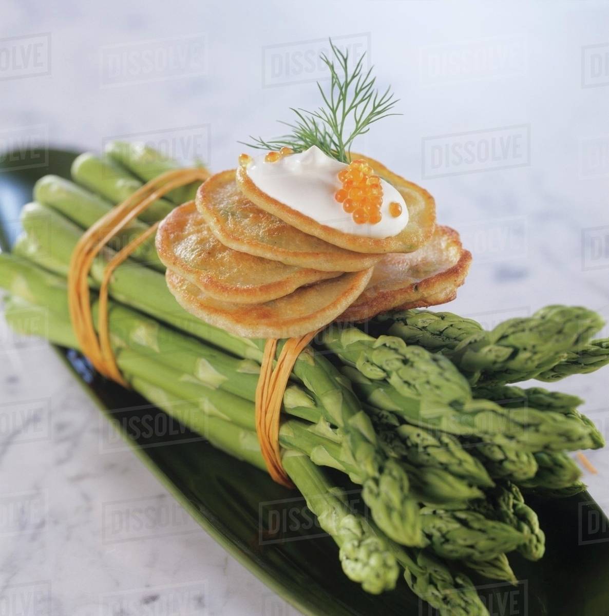 Blinis with sour cream and caviar on green asparagus - Royalty-free ...