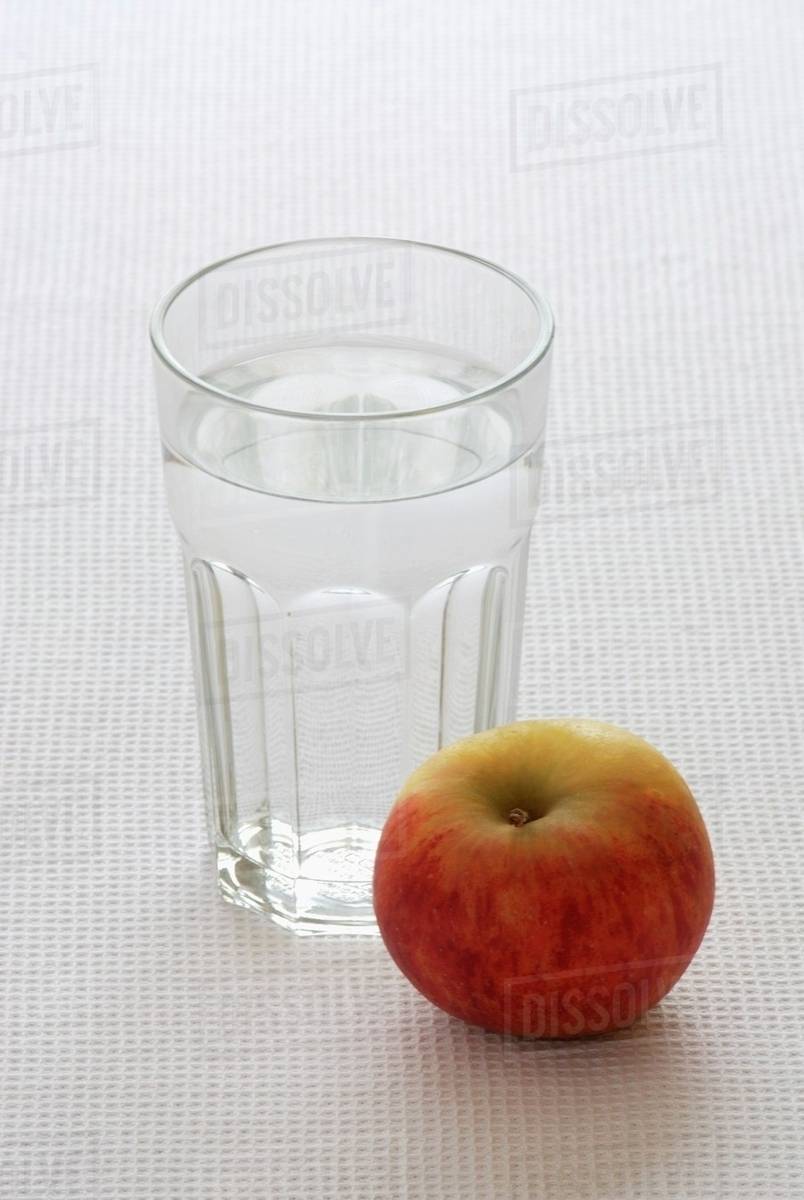 A glass of water and an apple - Royalty-free Stock Photo | Dissolve