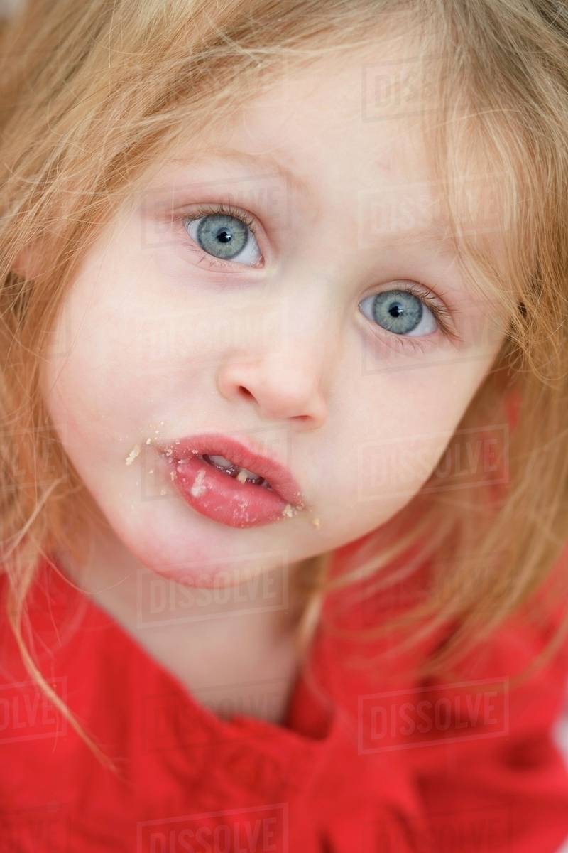 Small girl with crumbs around her mouth - Stock Photo - Dissolve