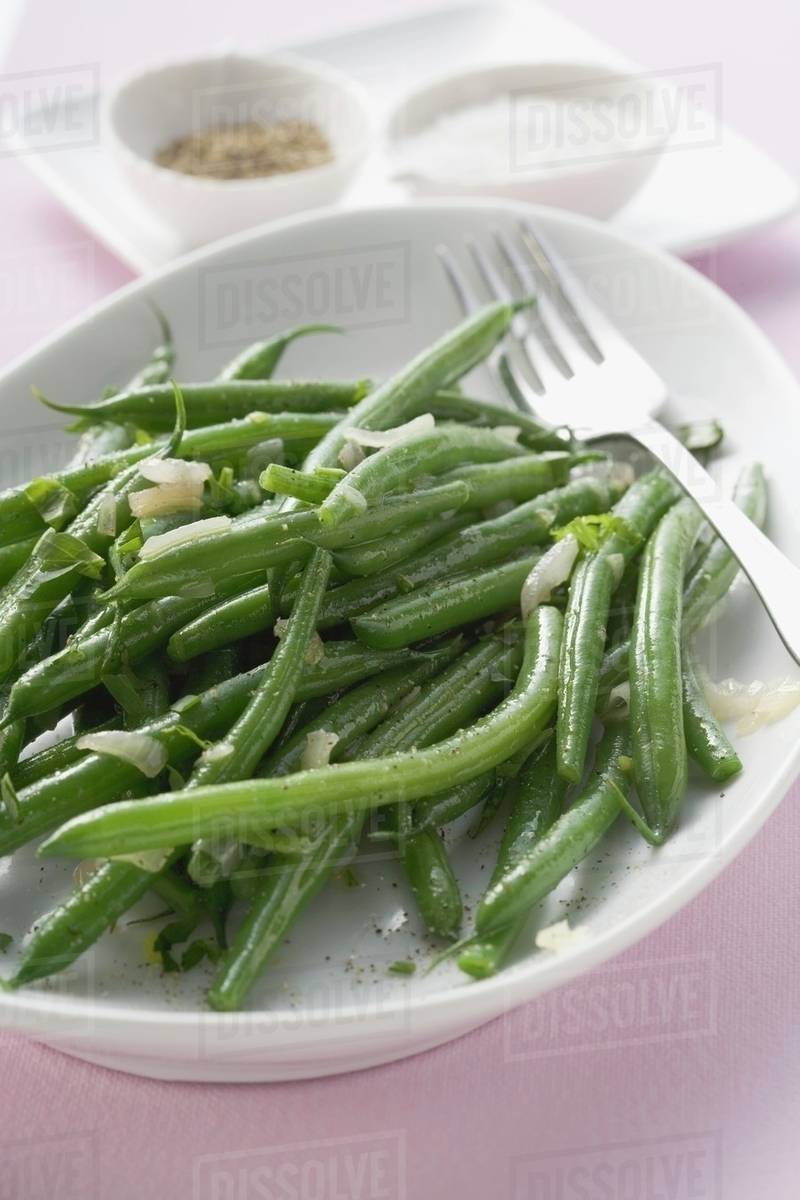 Green beans with onions, salt and pepper in background - Royalty-free ...