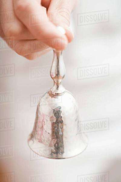 Hand holding silver bell - Royalty-free Stock Photo | Dissolve