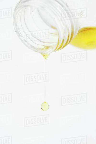 Olive oil dripping out of a bottle - Royalty-free Stock Photo | Dissolve