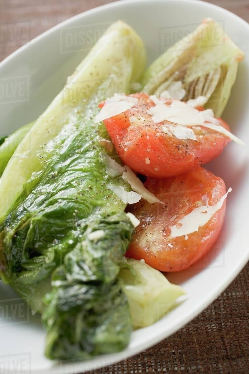 Braised romaine lettuce with tomatoes and Parmesan - Stock Photo - Dissolve